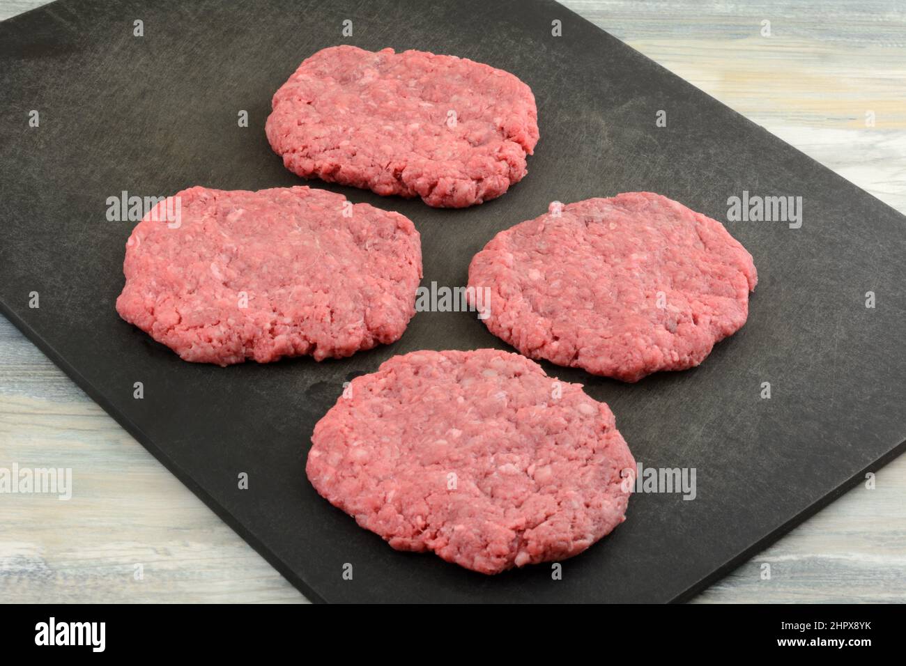 Raw formed ground beef hamburger patties on black cutting board Stock ...