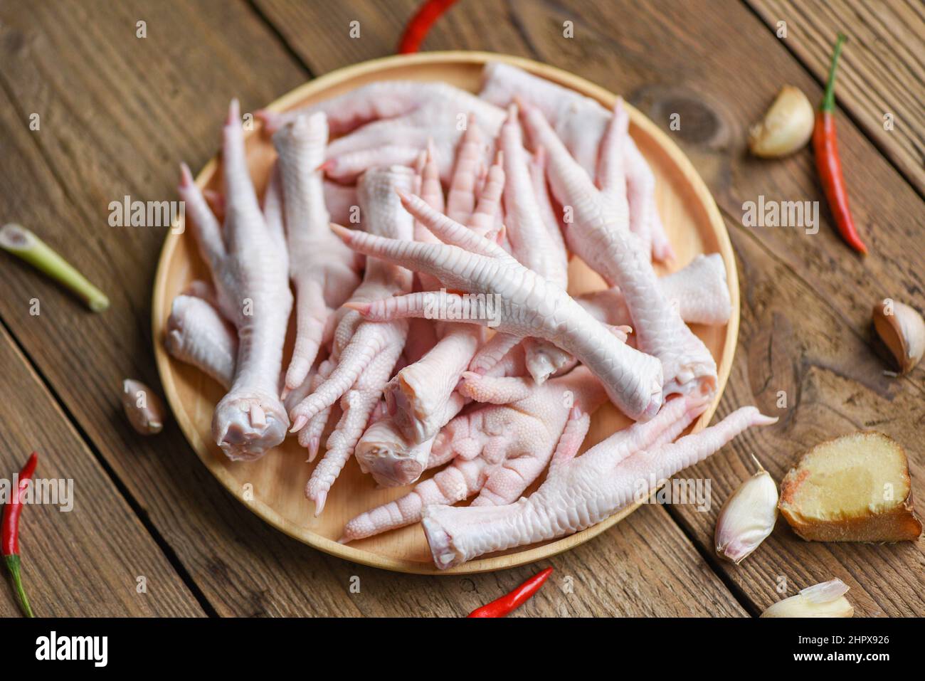 Fresh raw chicken feet for cooked food on the wooden table kitchen ...