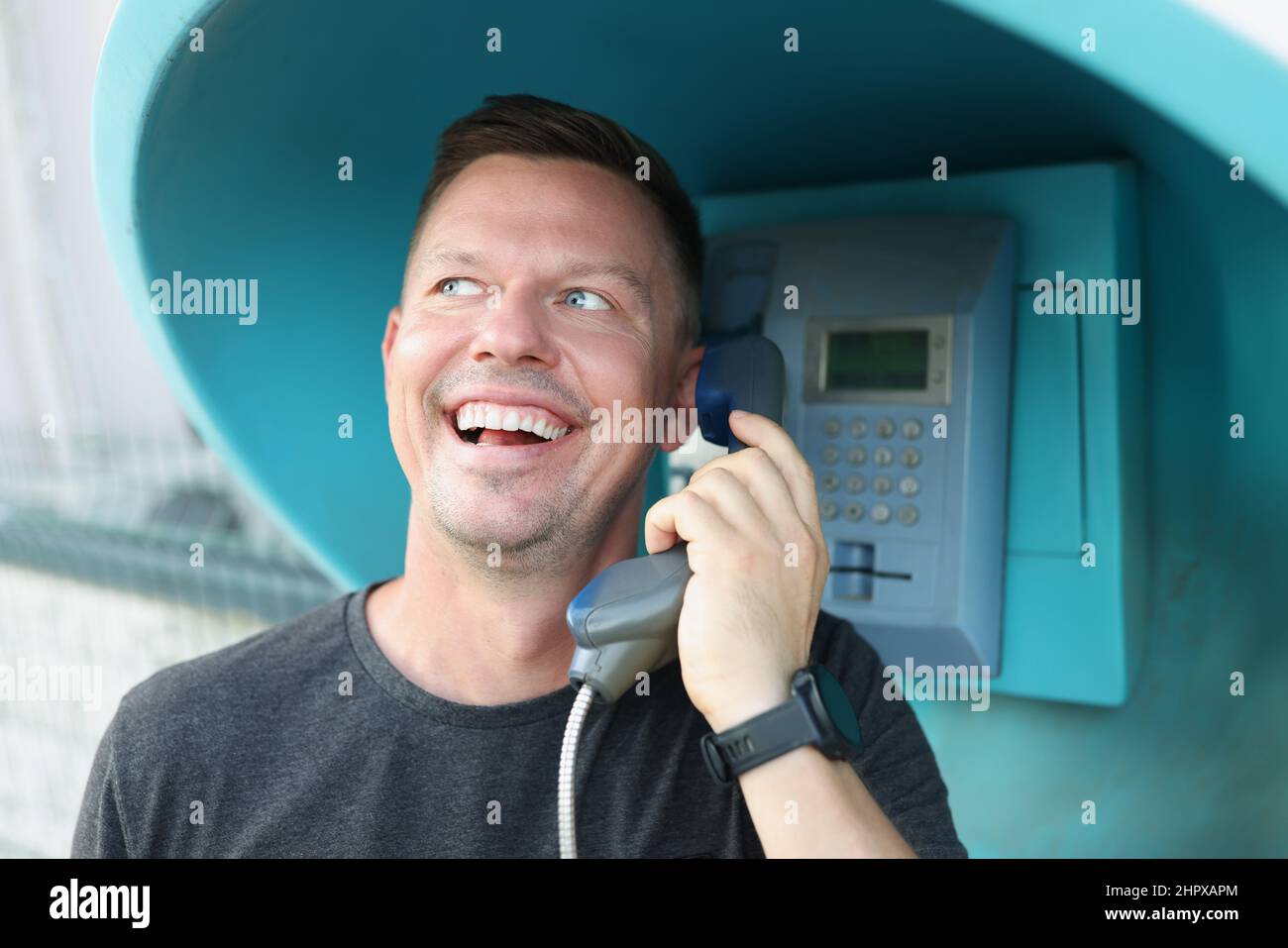 Happy man speaks on a public payphone, close-up Stock Photo - Alamy
