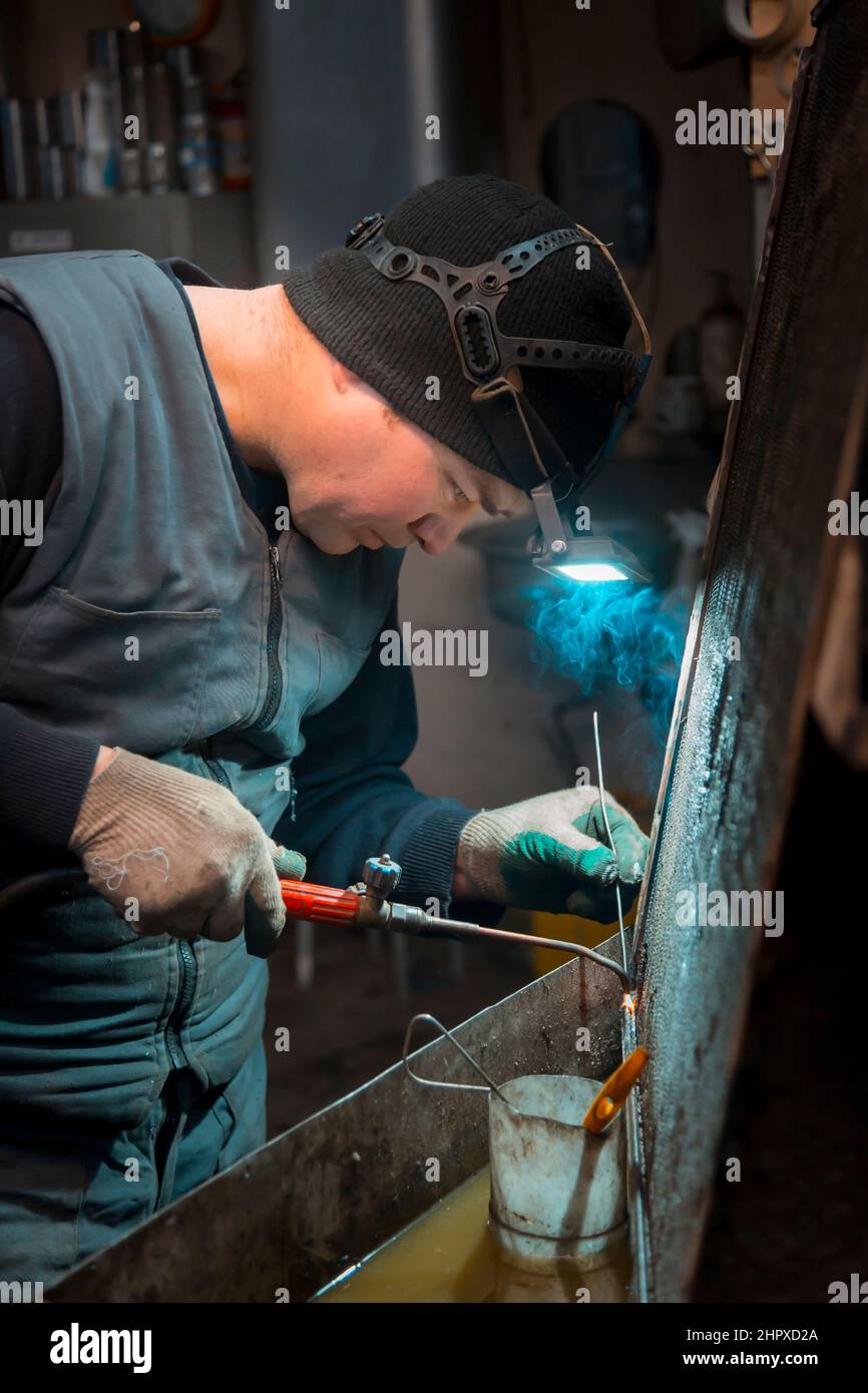 Welding a large car radiator with a gas torch Stock Photo - Alamy