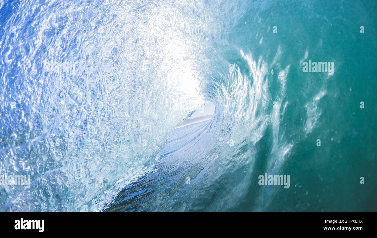 Ocean wave hollow crashing sea water onto shallow reef with back-light ...
