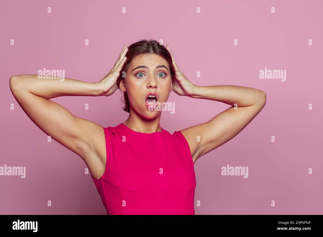 Cute worried nervous woman with panic expression on pink color ...