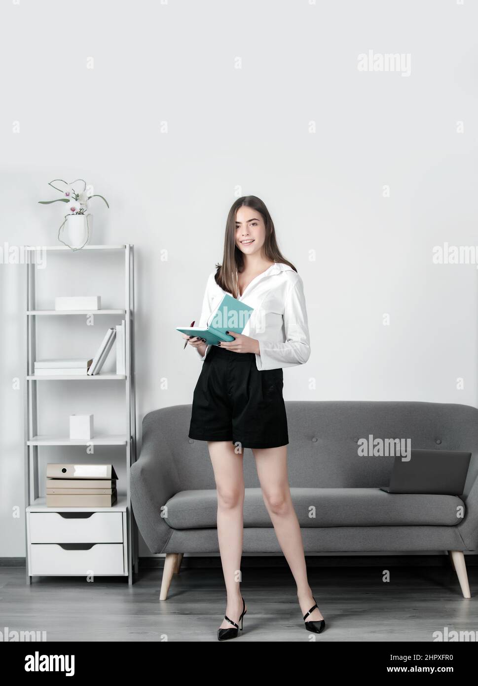 Young attractive secretary woman in a busy modern workplace in office ...