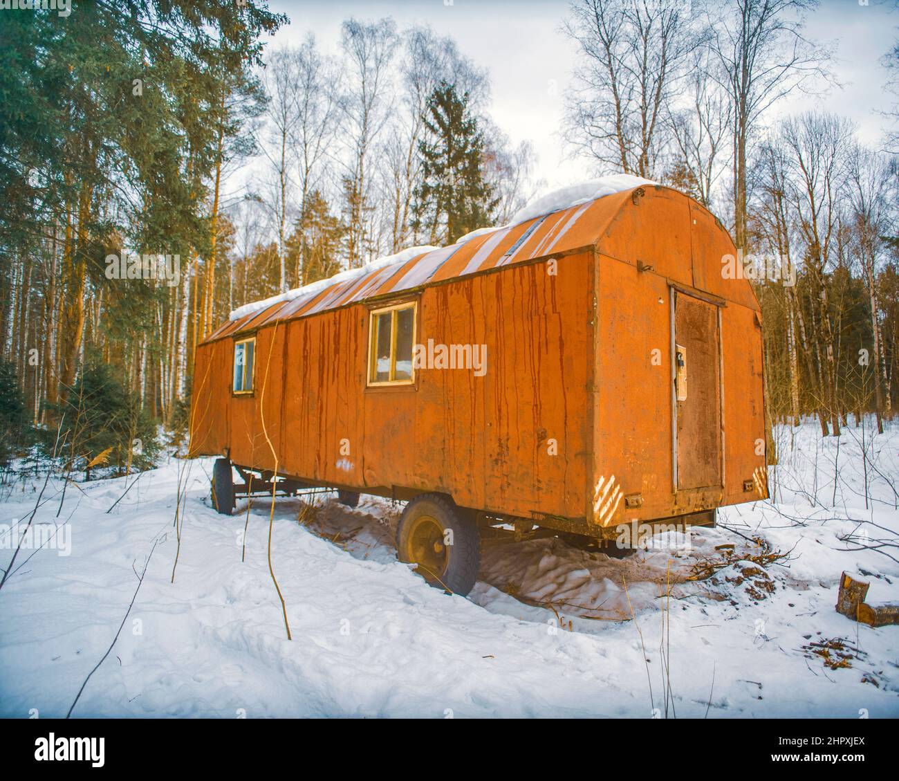 abandoned old rusty metal trailer in a winter forest, daylight shot ...