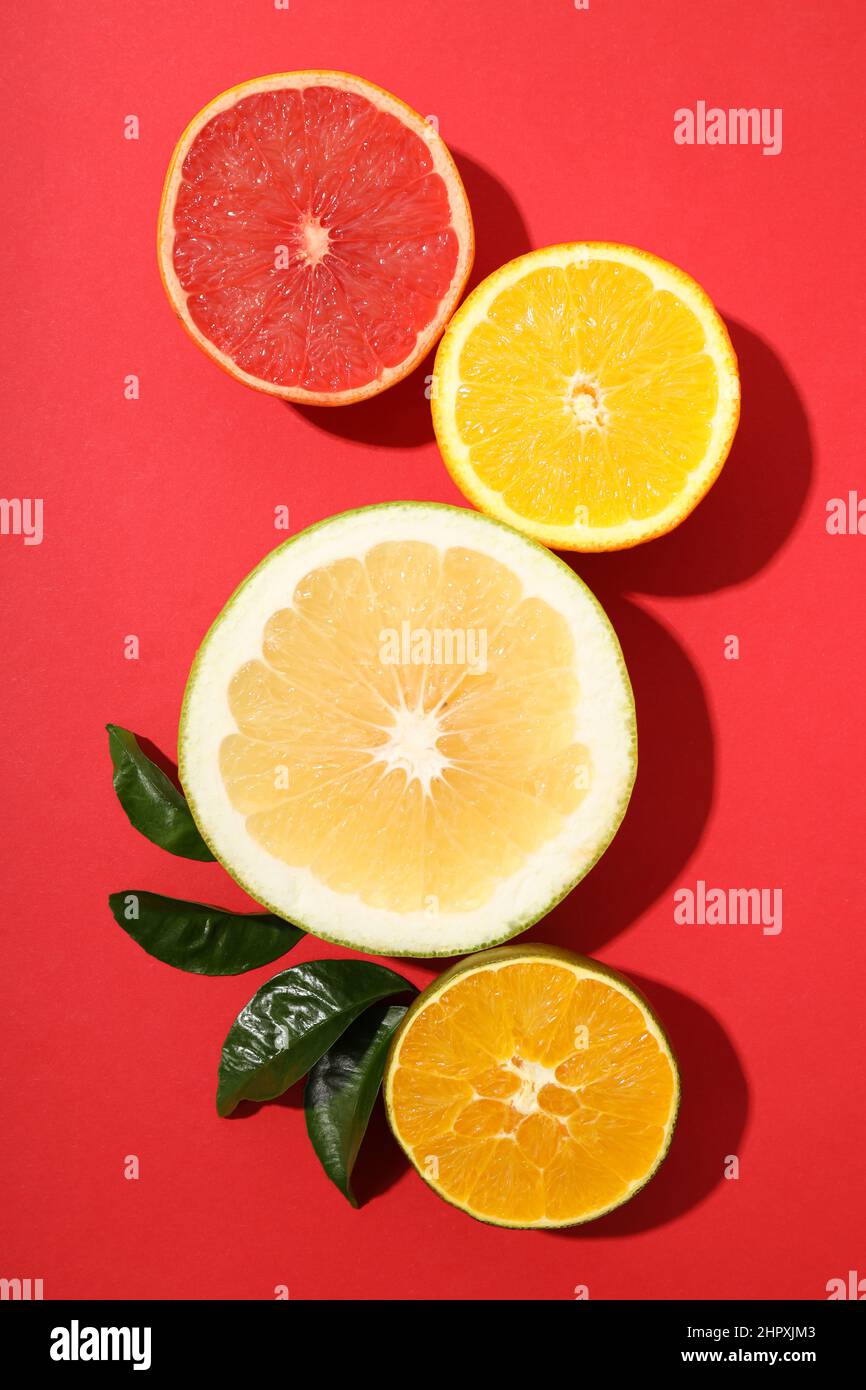 Citrus fruits halves with leaves on red background Stock Photo - Alamy