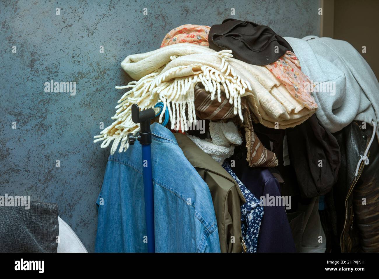 a room with a hanger and messy clothing, indoor shot Stock Photo - Alamy