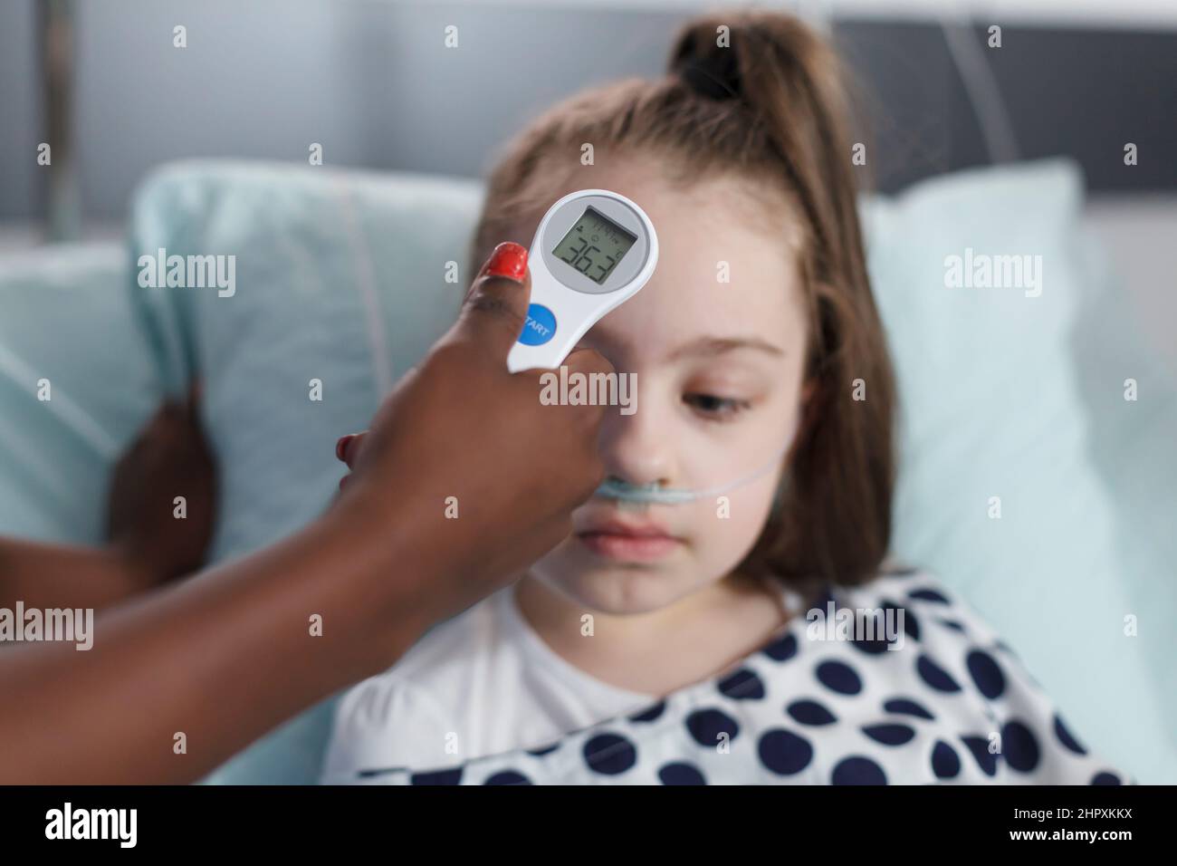 Close up of medical nurse measuring ill little girl body temperature ...