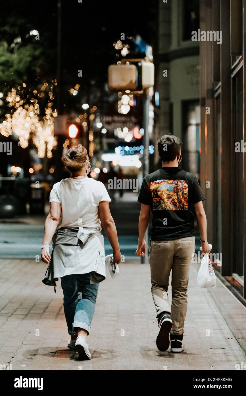 Vertical shot of a couple's night walk in the city Stock Photo - Alamy