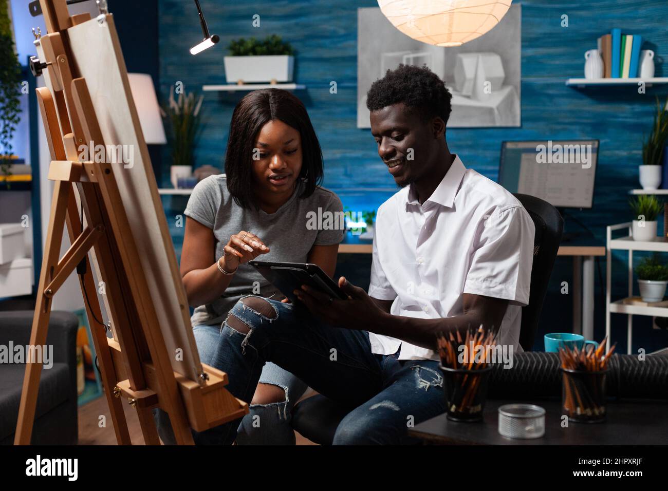 Young artists holding tablet computer looking at vase illustration ...