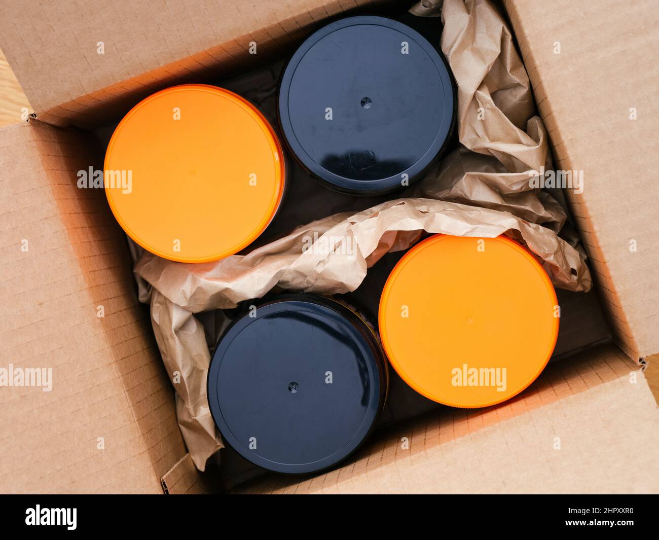 Four cans in a cardboard box. Close-up Stock Photo - Alamy