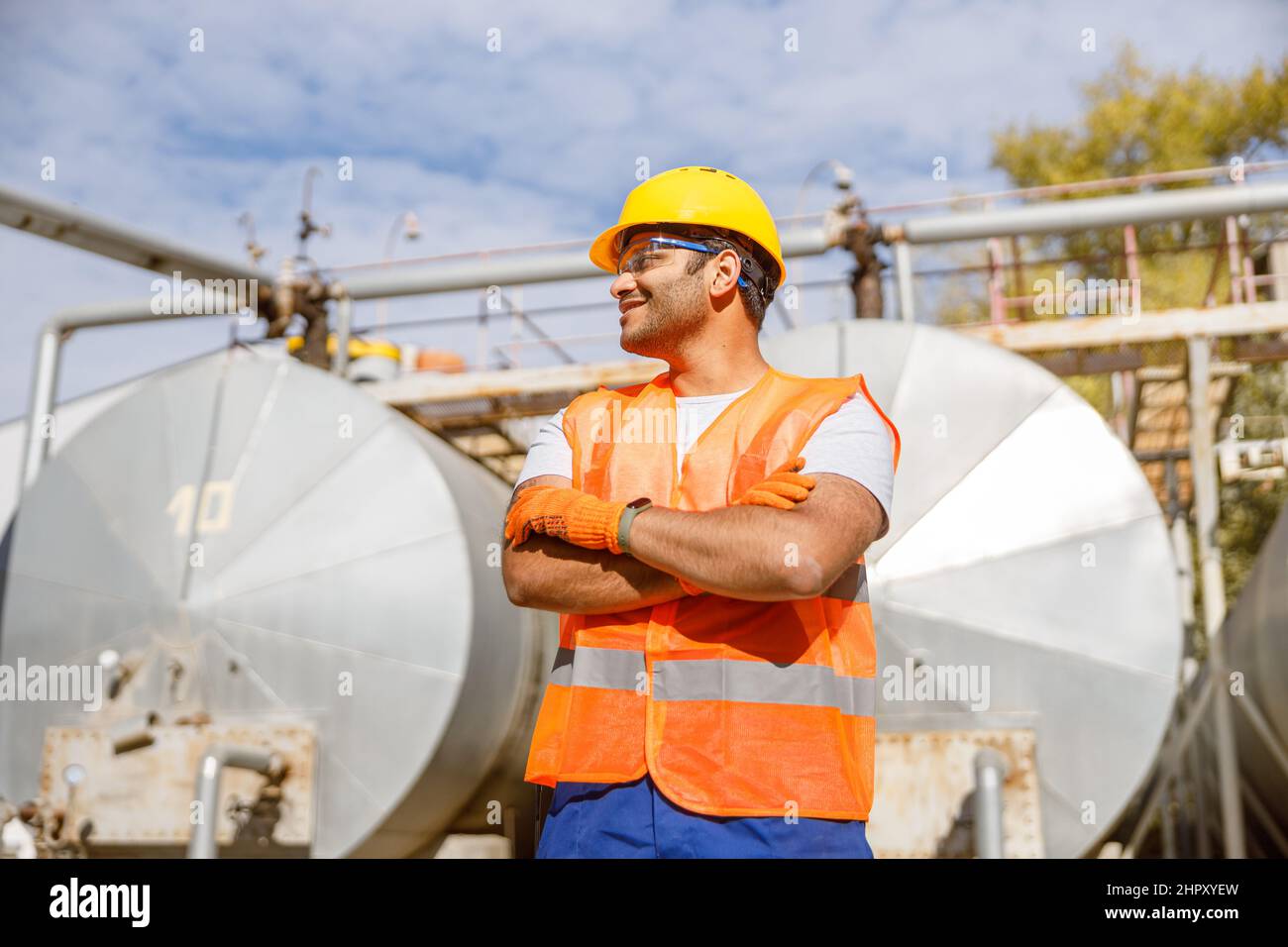 Worker with safety equipment working at construction plant Stock Photo ...
