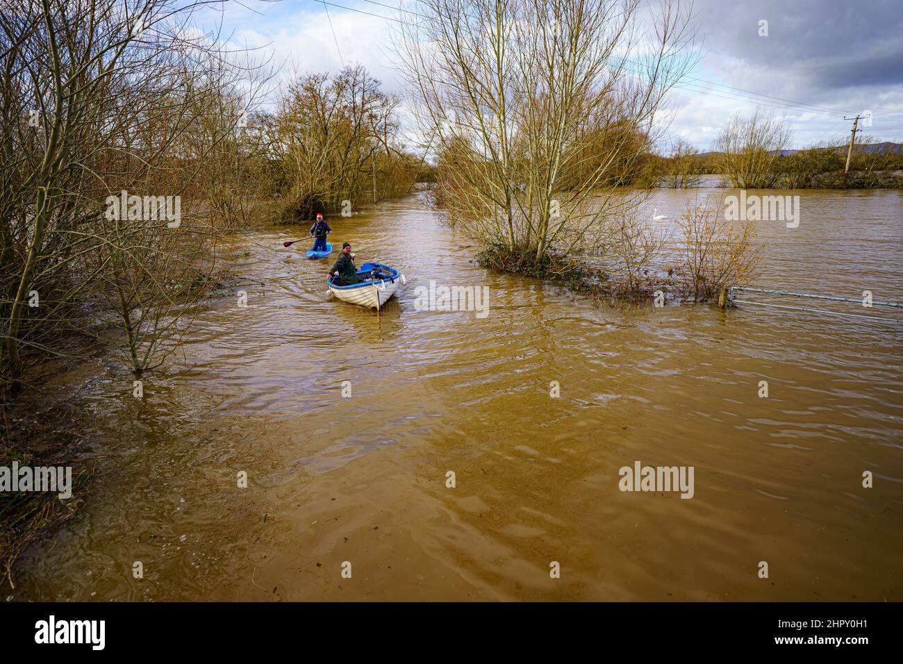 People on boats make their way along the flooded Ferry Lane at ...