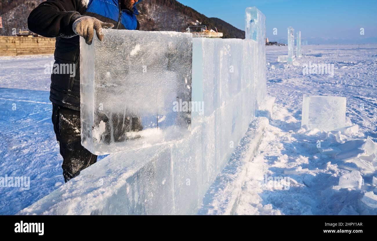Sculptor builds a wall from an ice block on Lake Baikal Stock Photo - Alamy