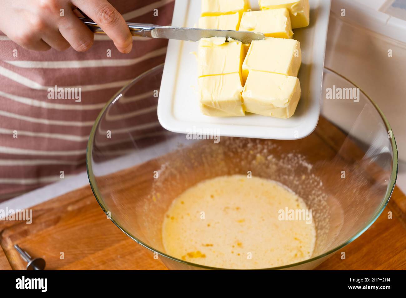 The dough preparation process. Female hands add butter into the mixing ...
