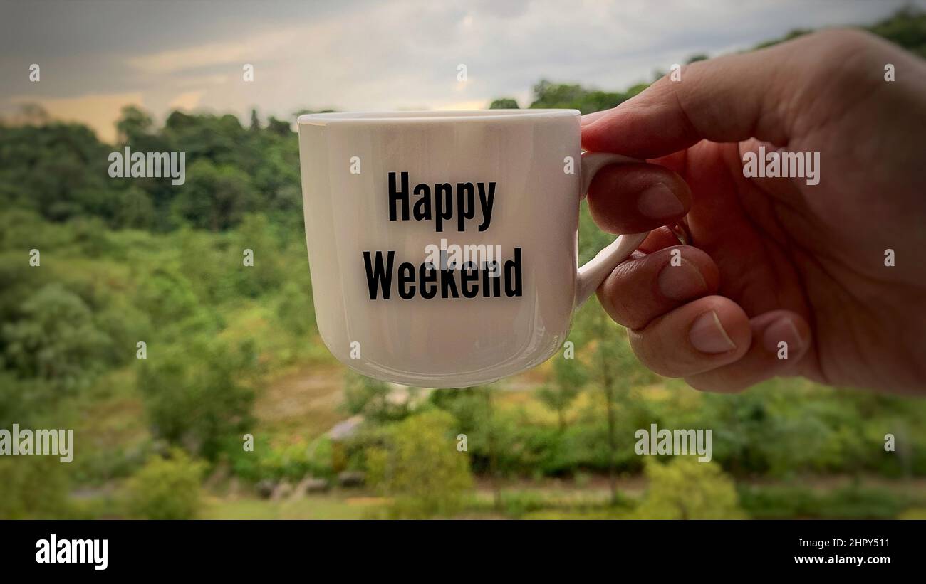 Morning greeting text - Happy weekend on coffee cup with blurred nature ...
