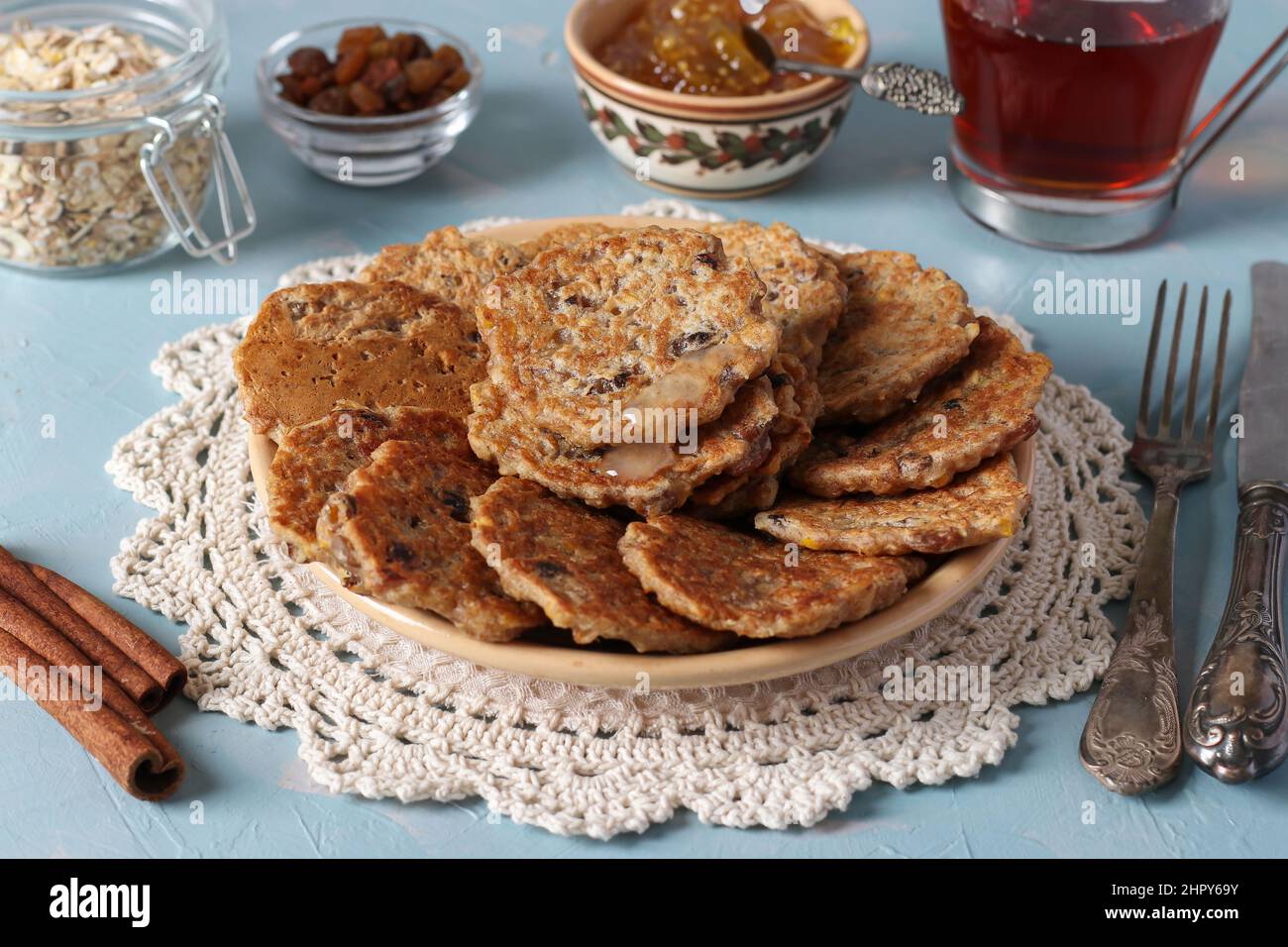 Oatmeal fritters with raisins are sprinkled with sweet syrup and served ...