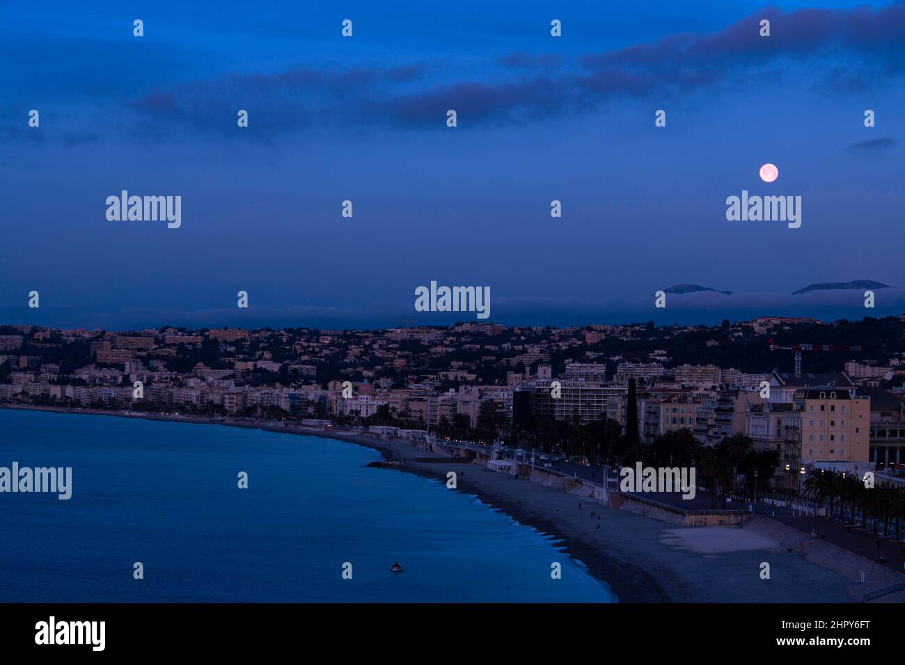 An aerial view of a full moon setting over the Baie des Anges and the ...