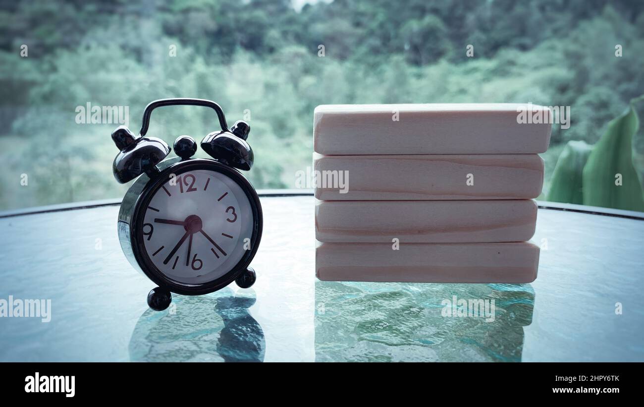 Black alarm clock with wooden blocks background. Copy space concept ...