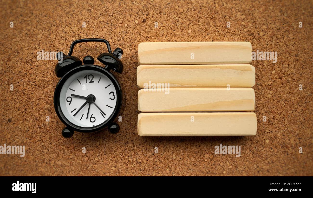 Top view of alarm clock and wooden blocks with brown desk background ...