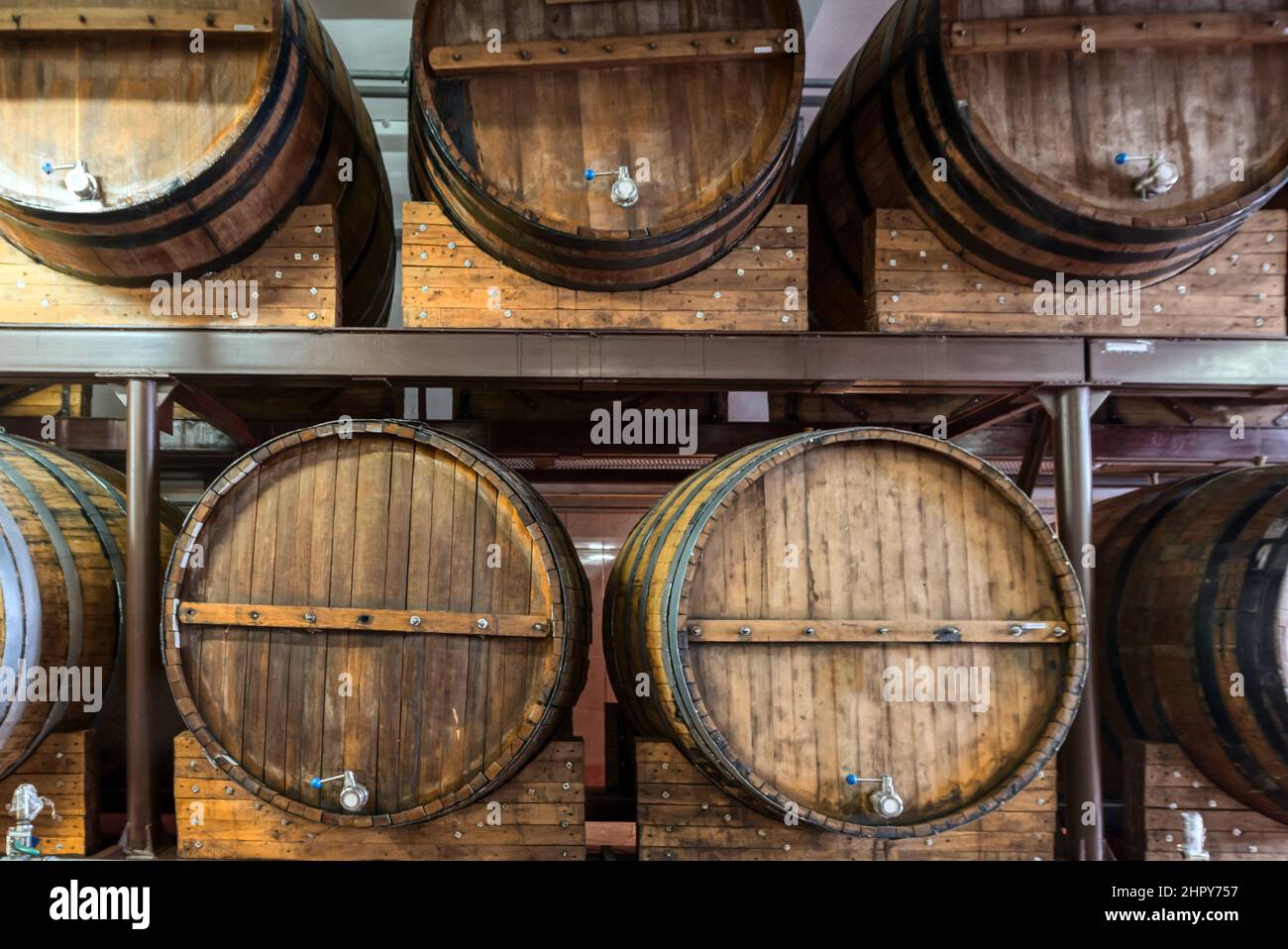 Line of wooden barrels of expensive alcohol drinks at plant Stock Photo ...