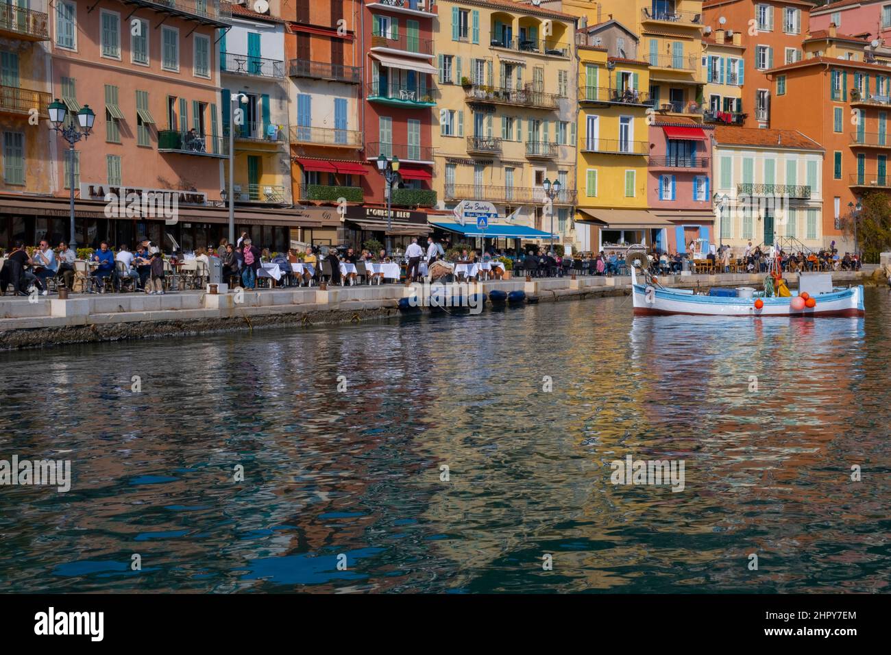A wooden fishing boat and colourfully painted old houses surrounding ...