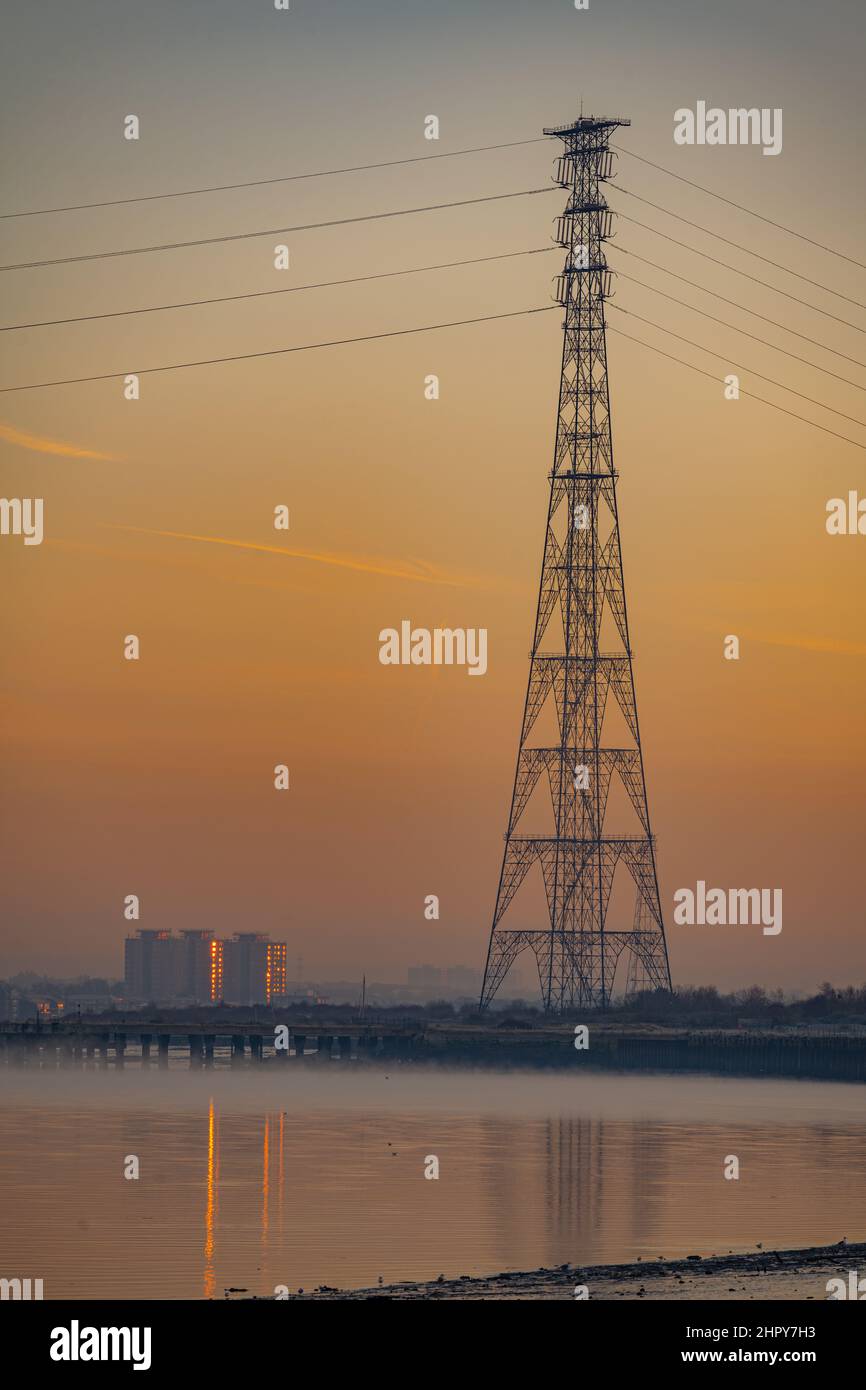 Sunrise behind the electricity pylon at Swanscombe Kent with Tilbury ...