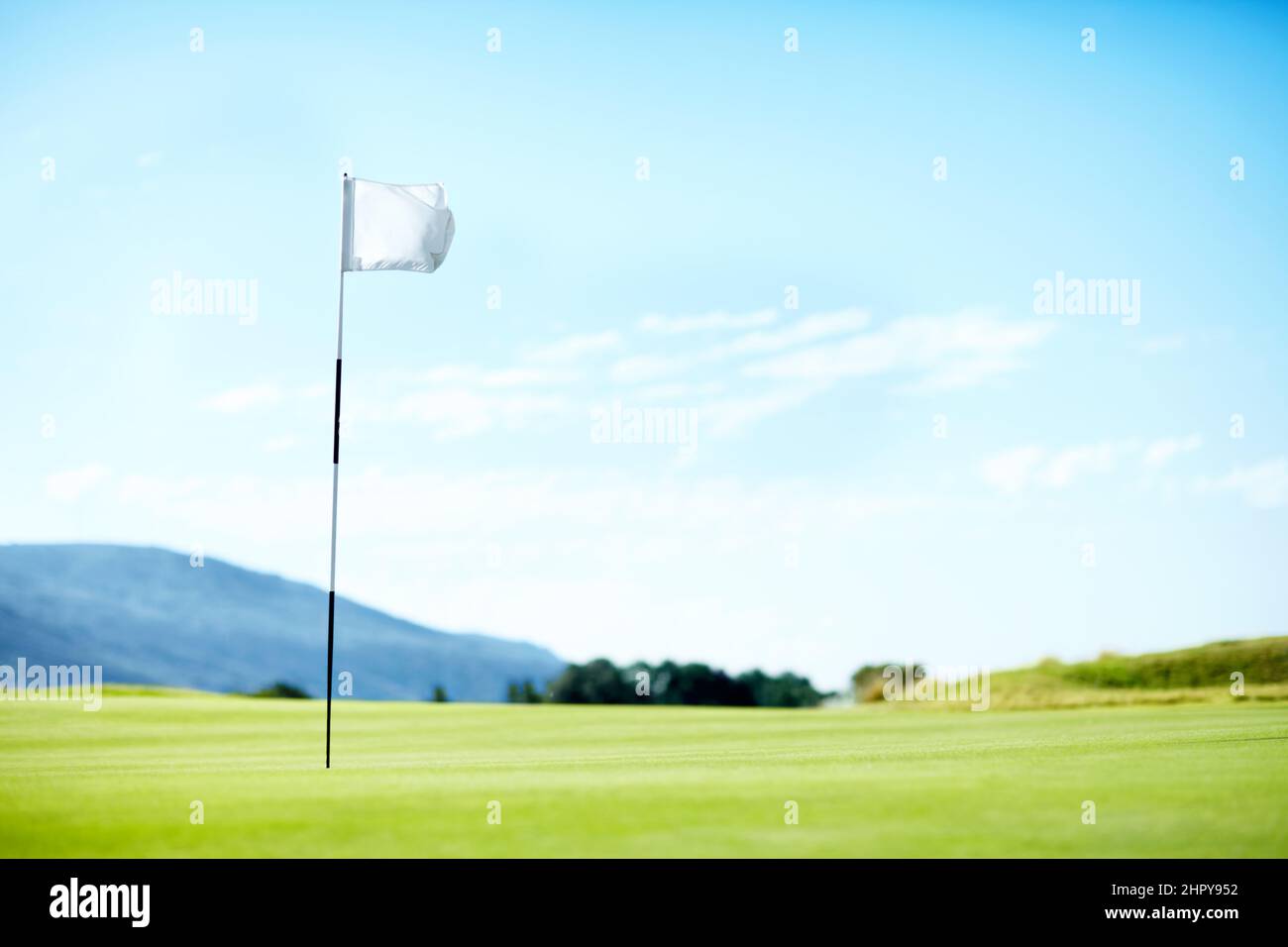 The end goal. Flag marking a hole on the golf course Stock Photo - Alamy