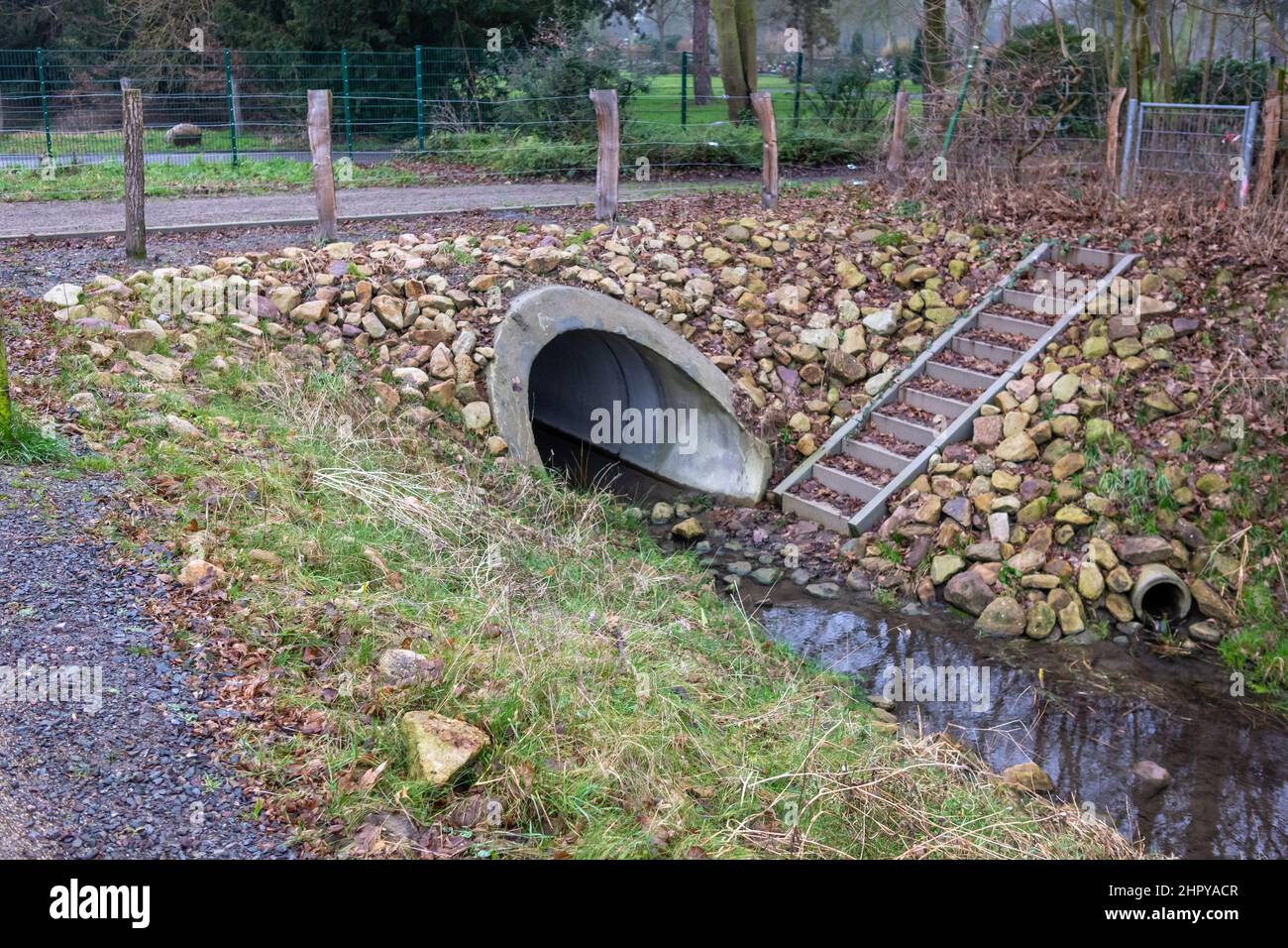 Drain canal with stairs and surrounded by big rocks Stock Photo - Alamy