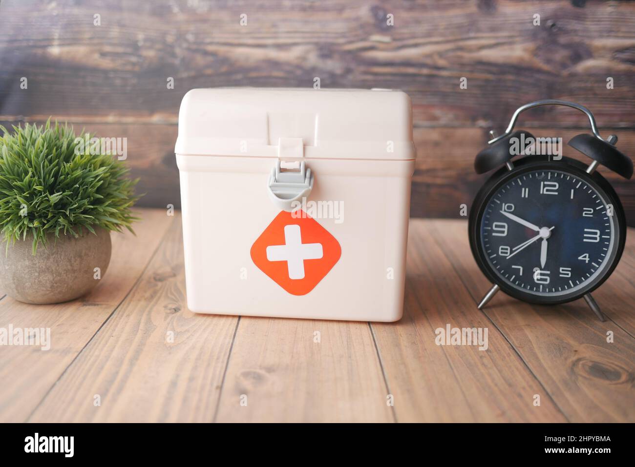 first aid kit box and a clock on table Stock Photo - Alamy