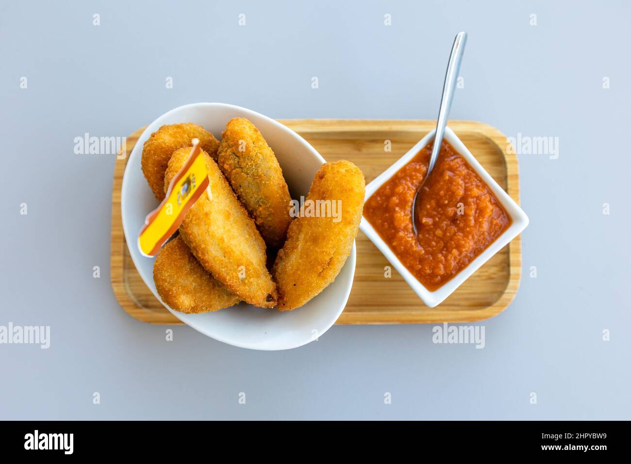 Closeup of tasty nuggets with a Spanish flag and a sauce on a wooden ...