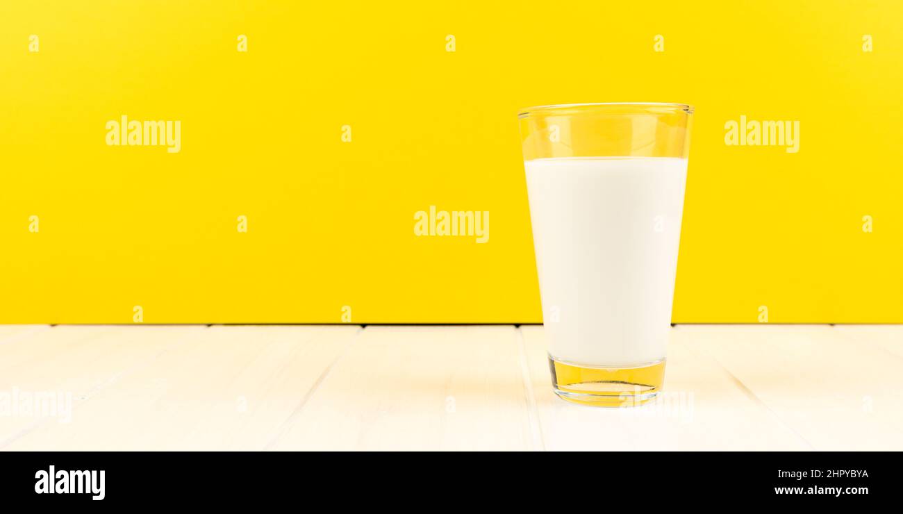 Closeup shot of a cup of milk on the yellow background Stock Photo - Alamy
