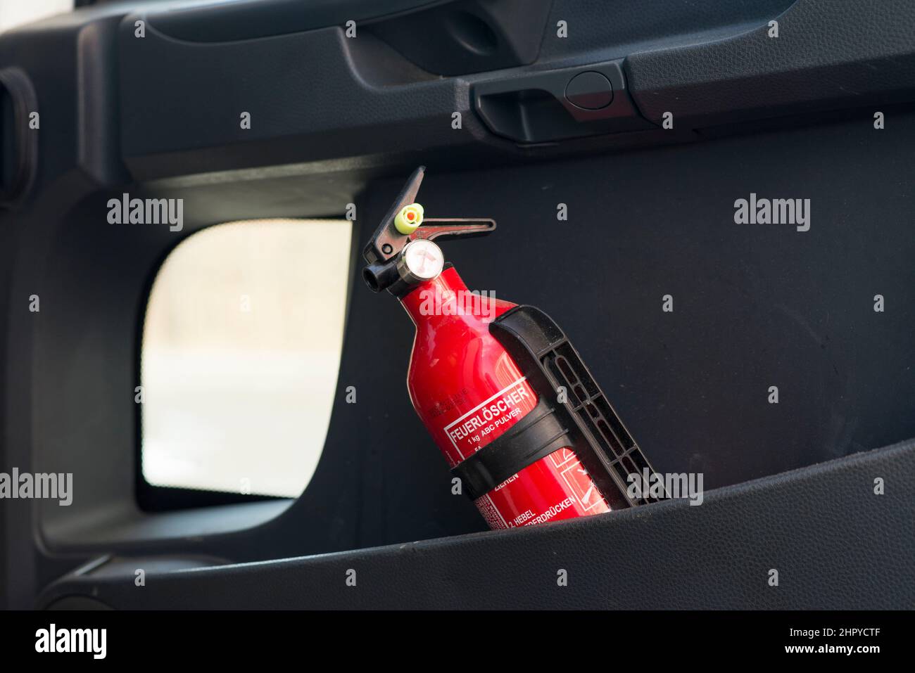 Red fire extinguisher in a black truck door Stock Photo - Alamy