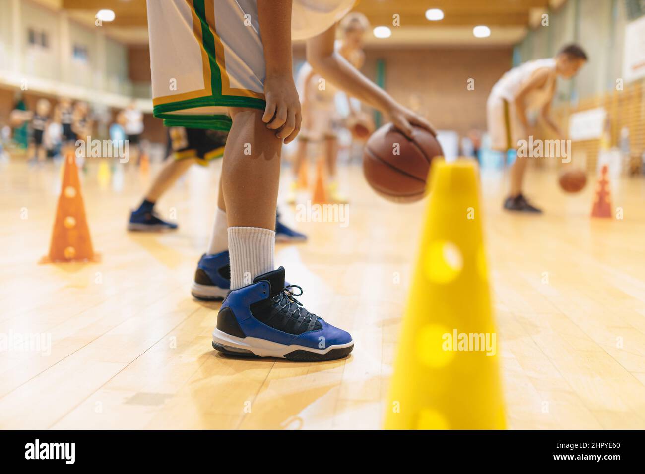Young basketball players bounce balls on training session. School of ...