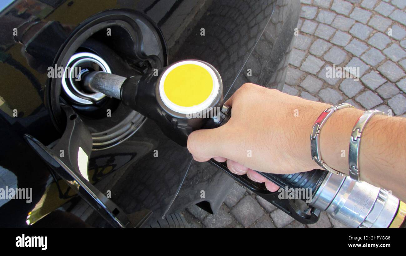 Hand using a fuel pipe. Refueling at the petrol station Stock Photo - Alamy