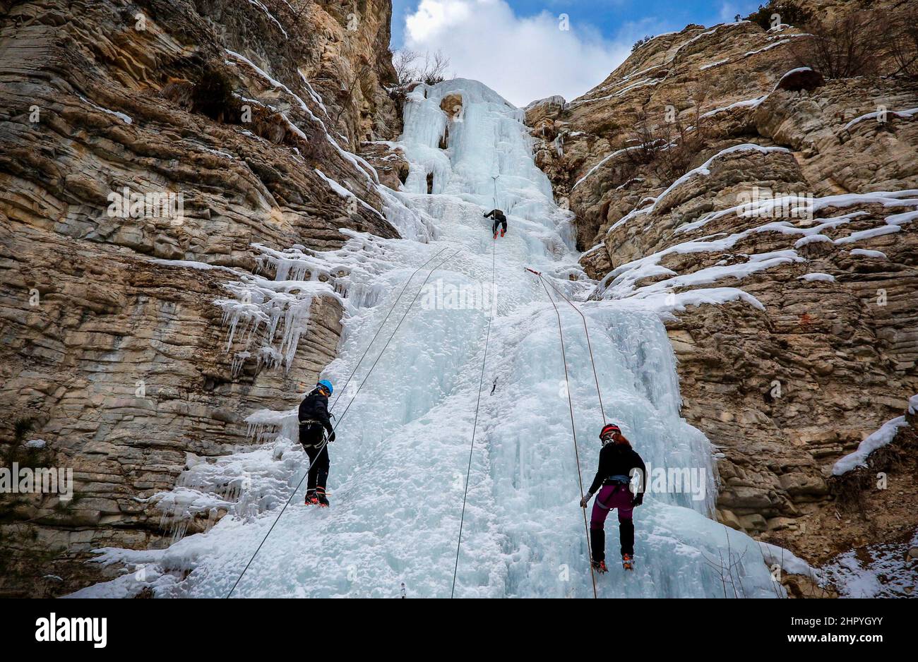 Group of ice climbers climbing a steep frozen waterfall in winter Stock ...