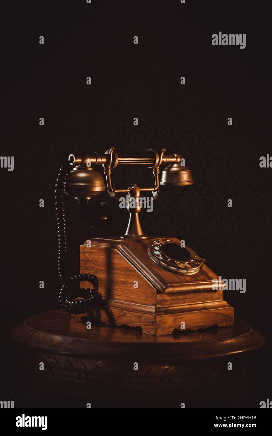 Closeup of an antique telephone made of wood and copper on a table ...