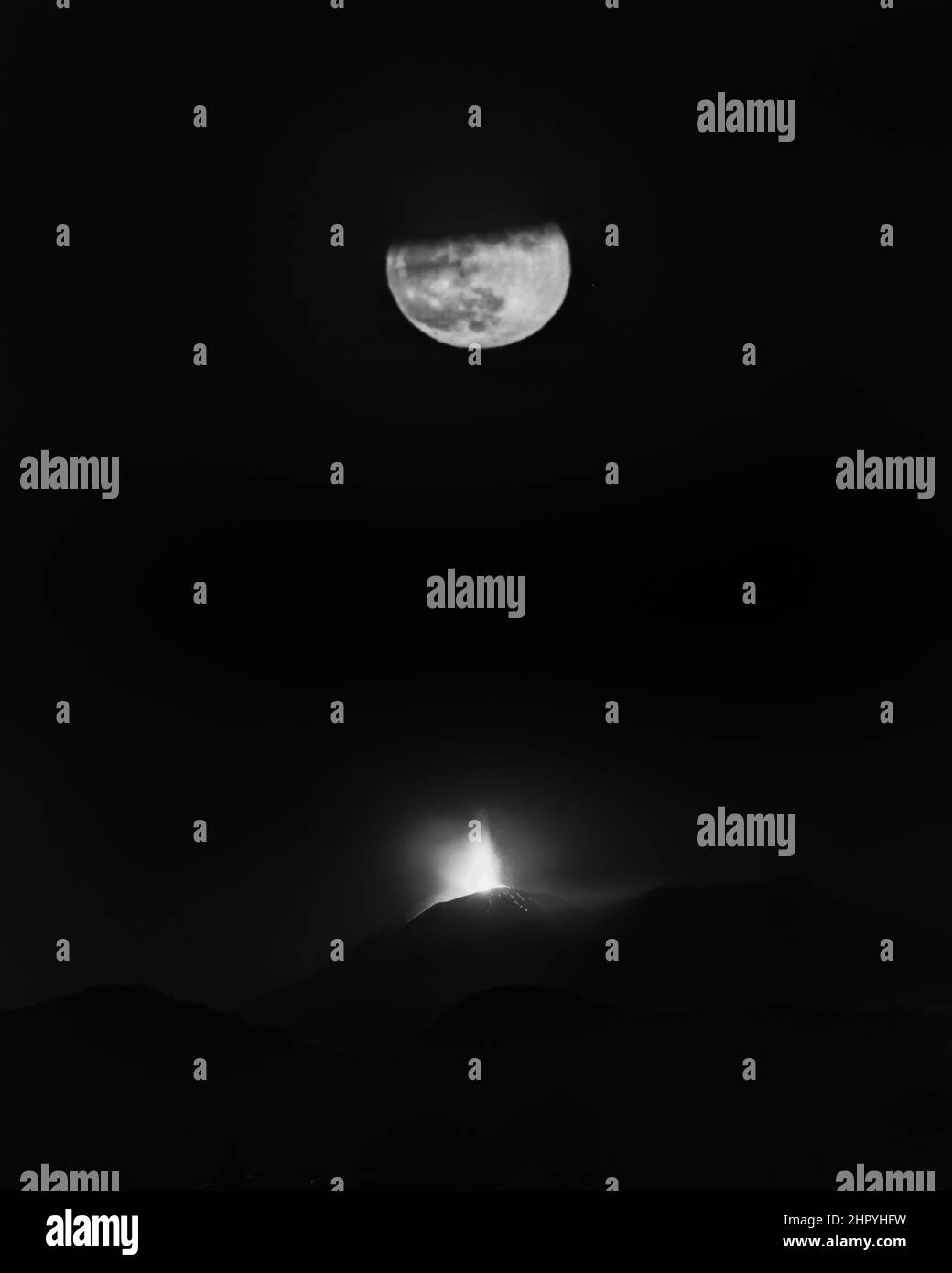 Grayscale shot of the full moon over an erupting volcano in Sicily ...