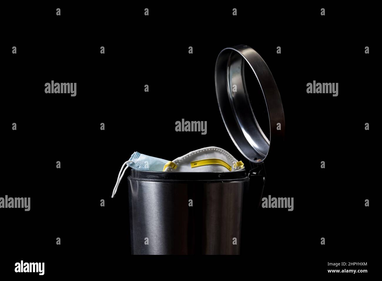 Closeup of a man throwing a used mask in trash bin Stock Photo - Alamy