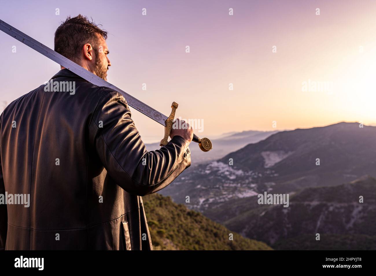 Man wearing a leather coat and holding a sword Stock Photo - Alamy