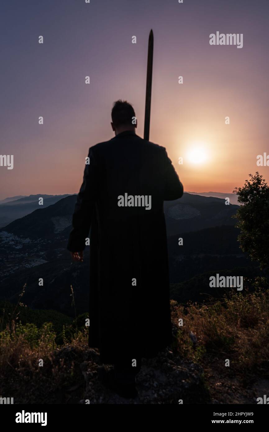 Man wearing a leather coat and holding a sword Stock Photo - Alamy