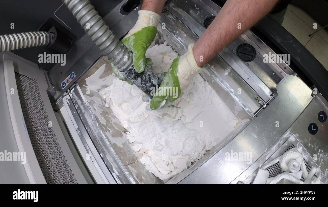 Man cleans details printed on industrial 3D printer from white plastic ...