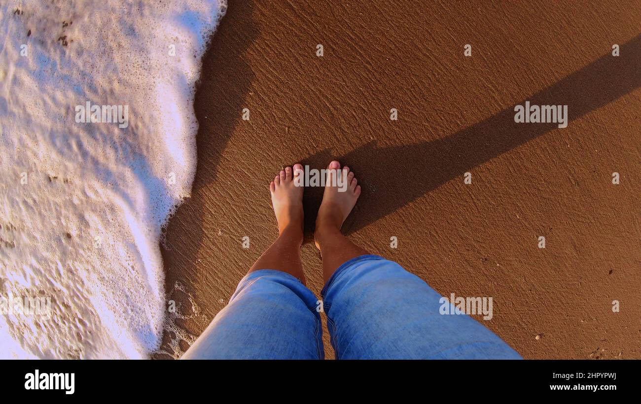 Girl standing on sandy beach. Sea ocean wave with white foam rolls ...