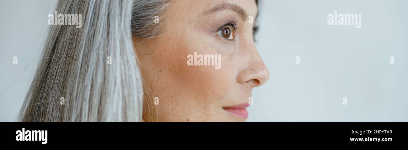 Middle aged Asian woman with beautiful straight hoary hair on light ...