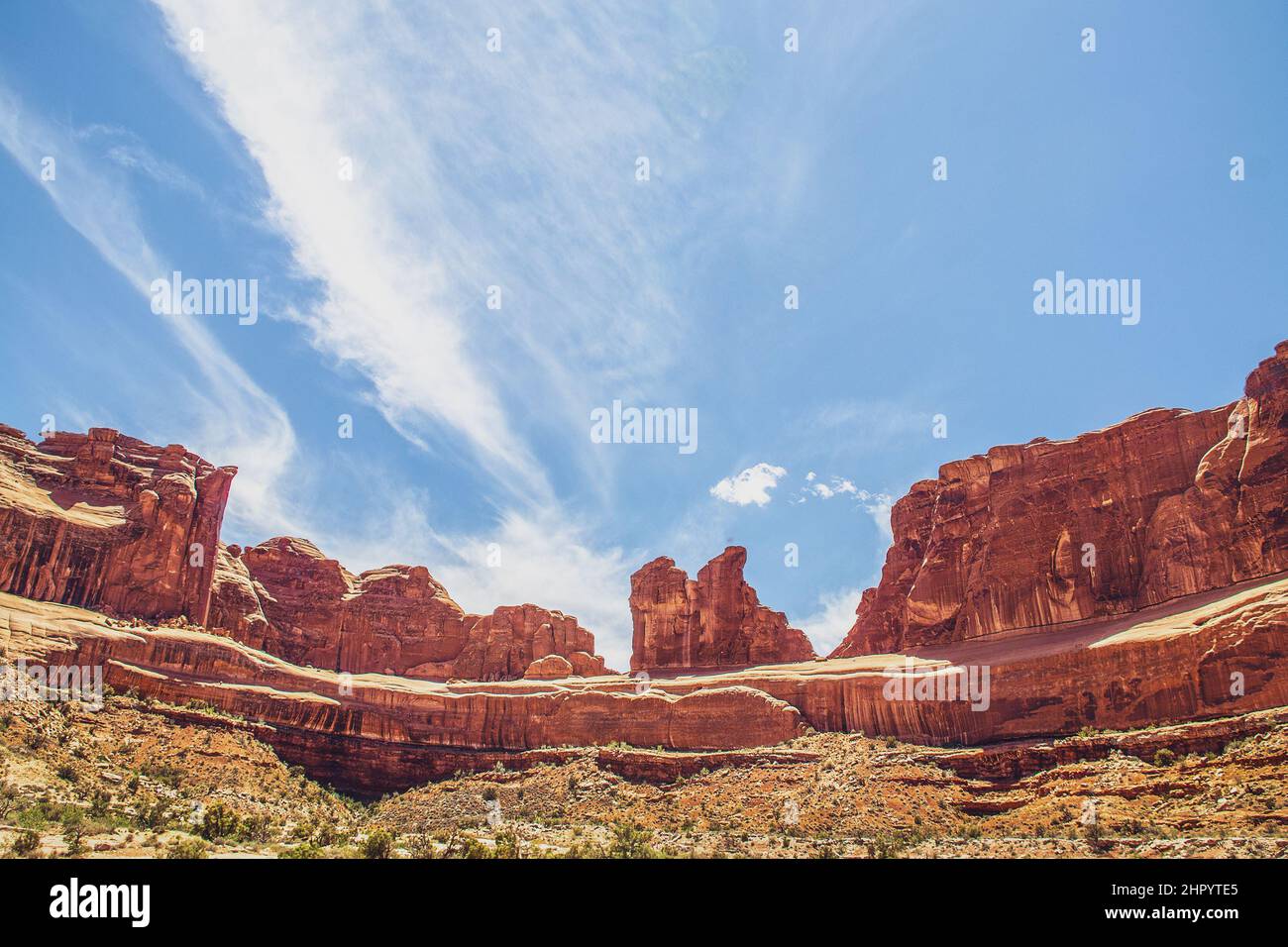 Wide angle of startk red bluffs under dramtic sky at Arches National ...