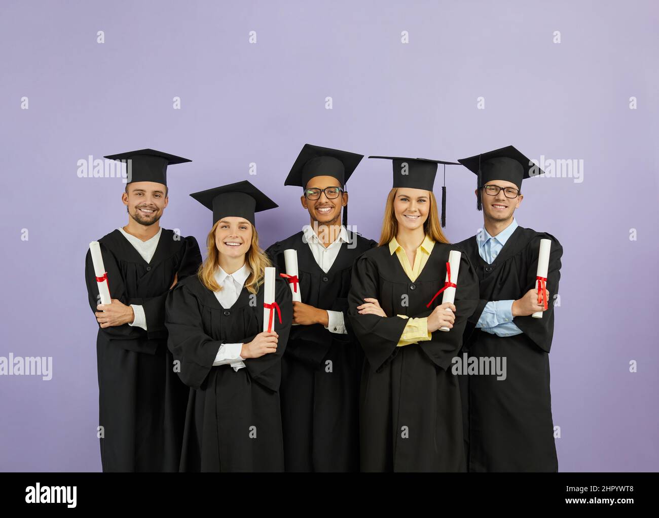Group of happy multiracial university graduates with diplomas in their ...