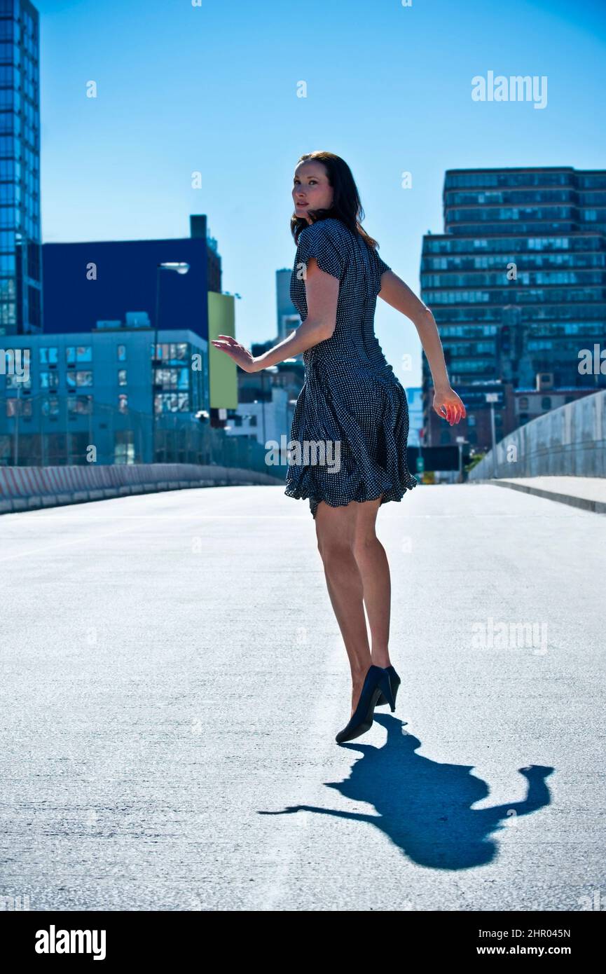 Silhouetted woman running down street, rear view Stock Photo - Alamy