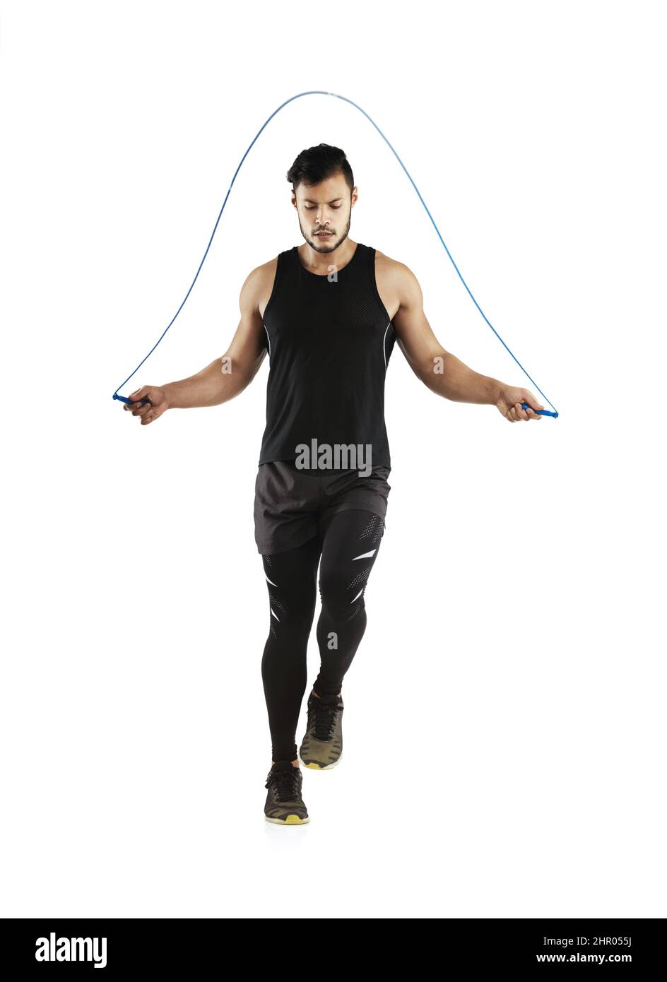Studio shot of a young man skipping with a jump rope against a white ...
