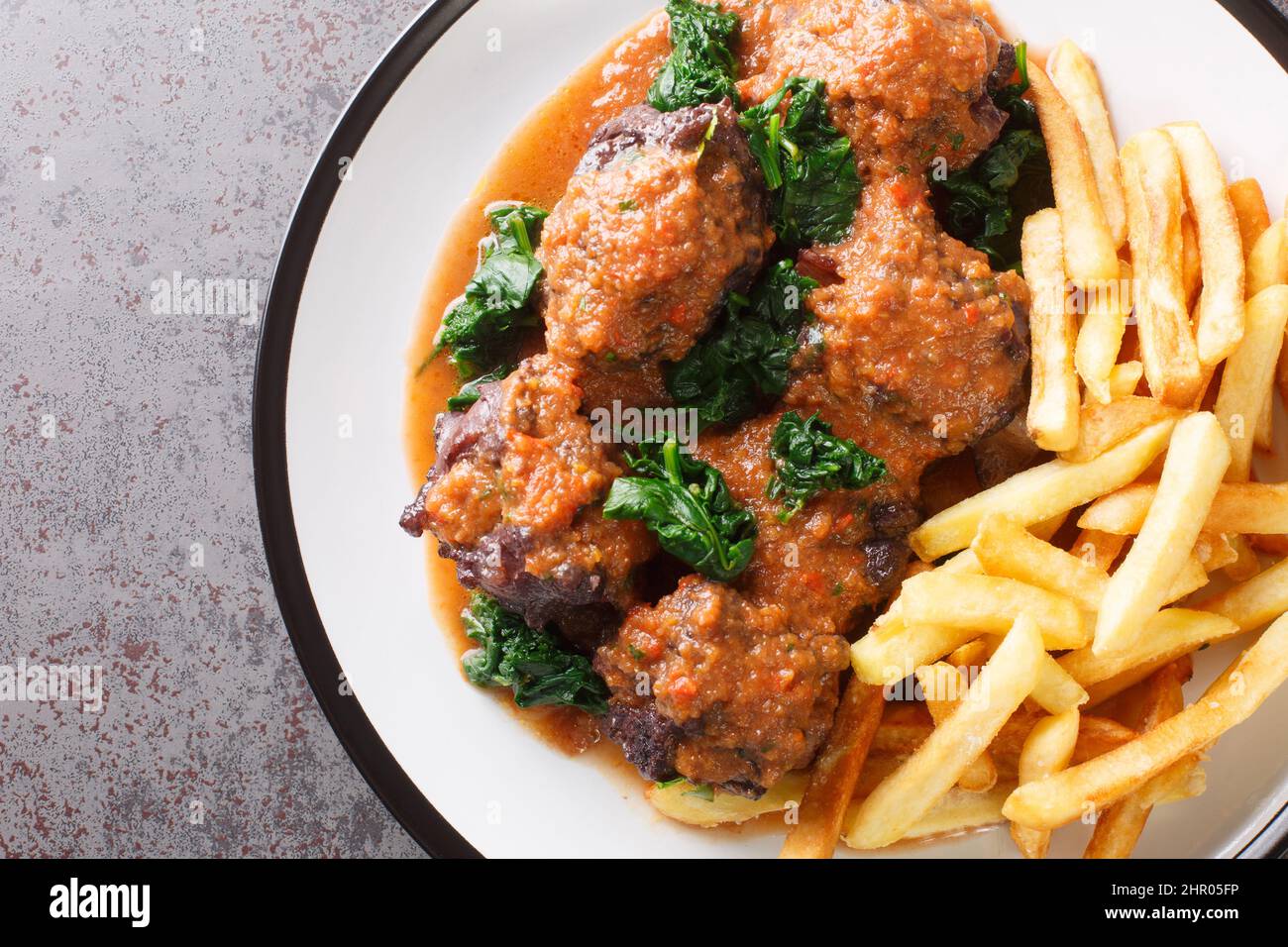 Meat for bull tail stew Rabo de toro served with french fries on white ...