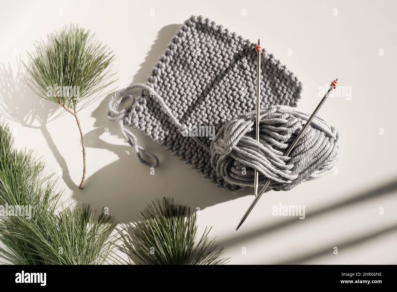 Knitting peace and rope on white table and fir tree natural light ...