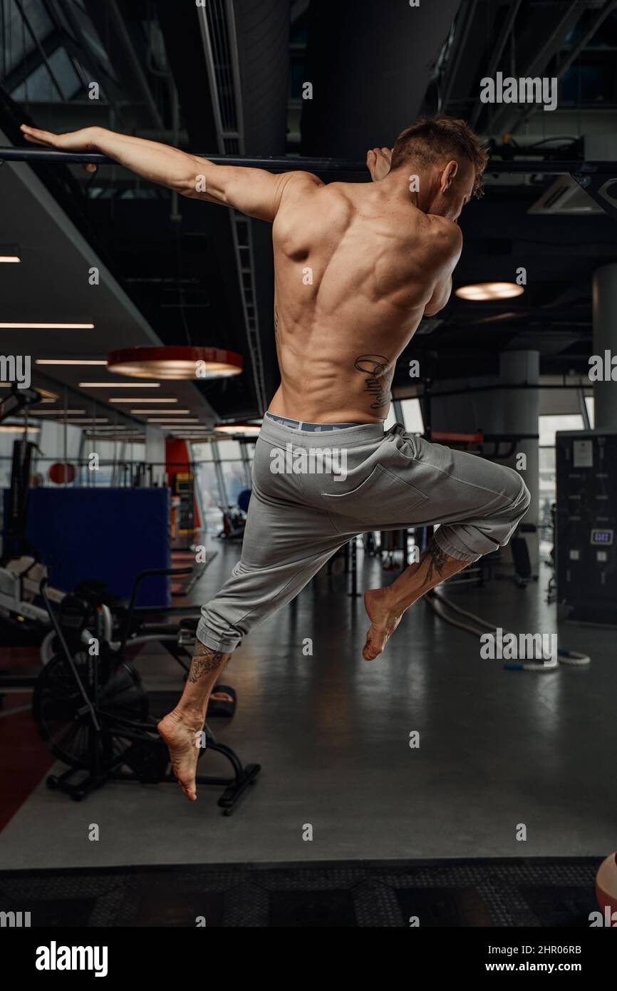 Muscular strong man exercising in the sport gym, Man doing horizontal ...